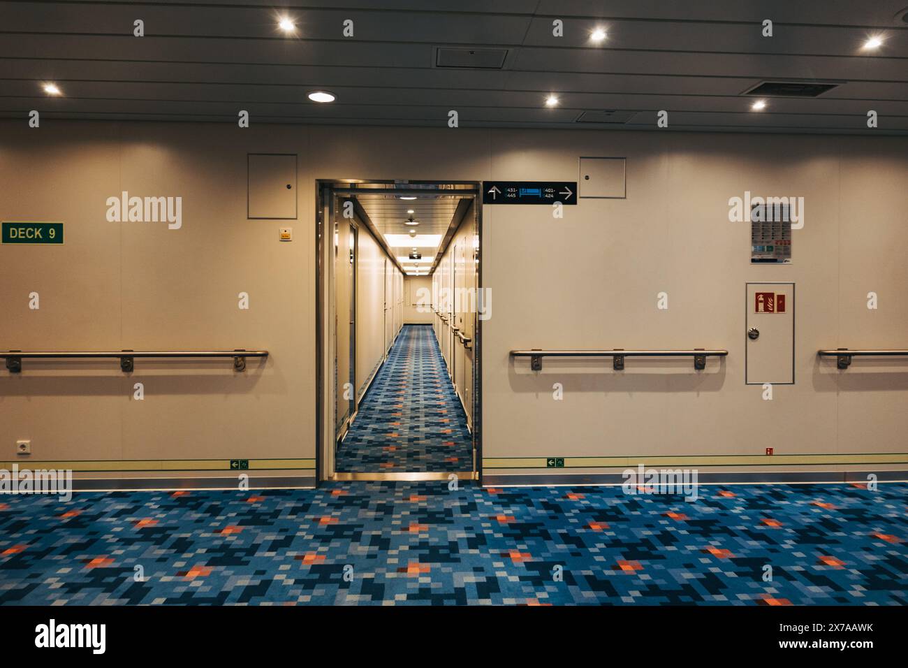 the white walls and blue carpet of the passenger cabin hallway of a ...