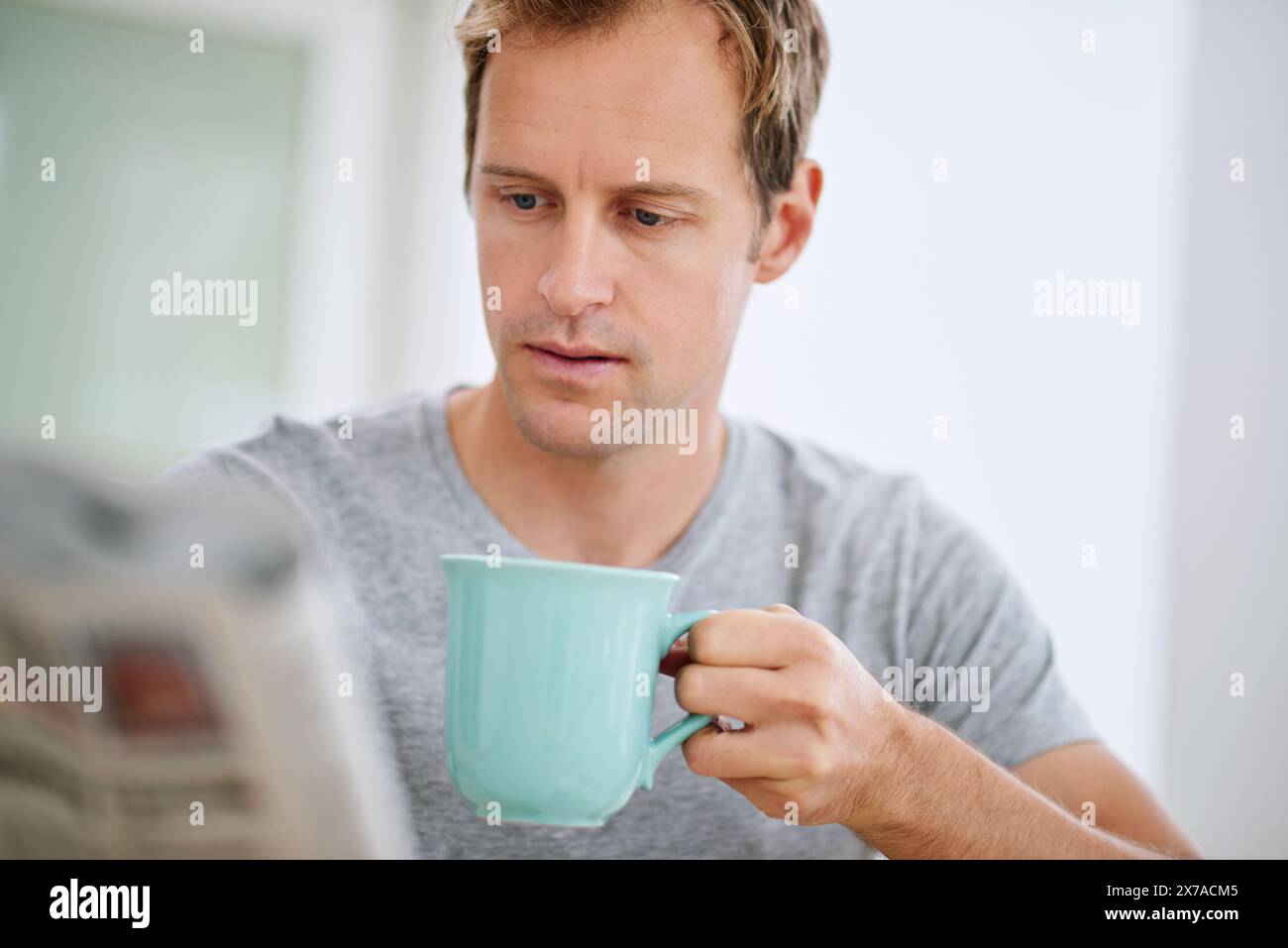 Man, serious and newspaper in morning with coffee for breaking news or ...