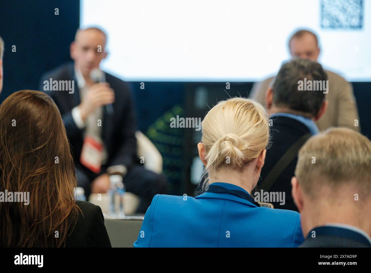 A business conference featuring a speaker and audience members in a ...
