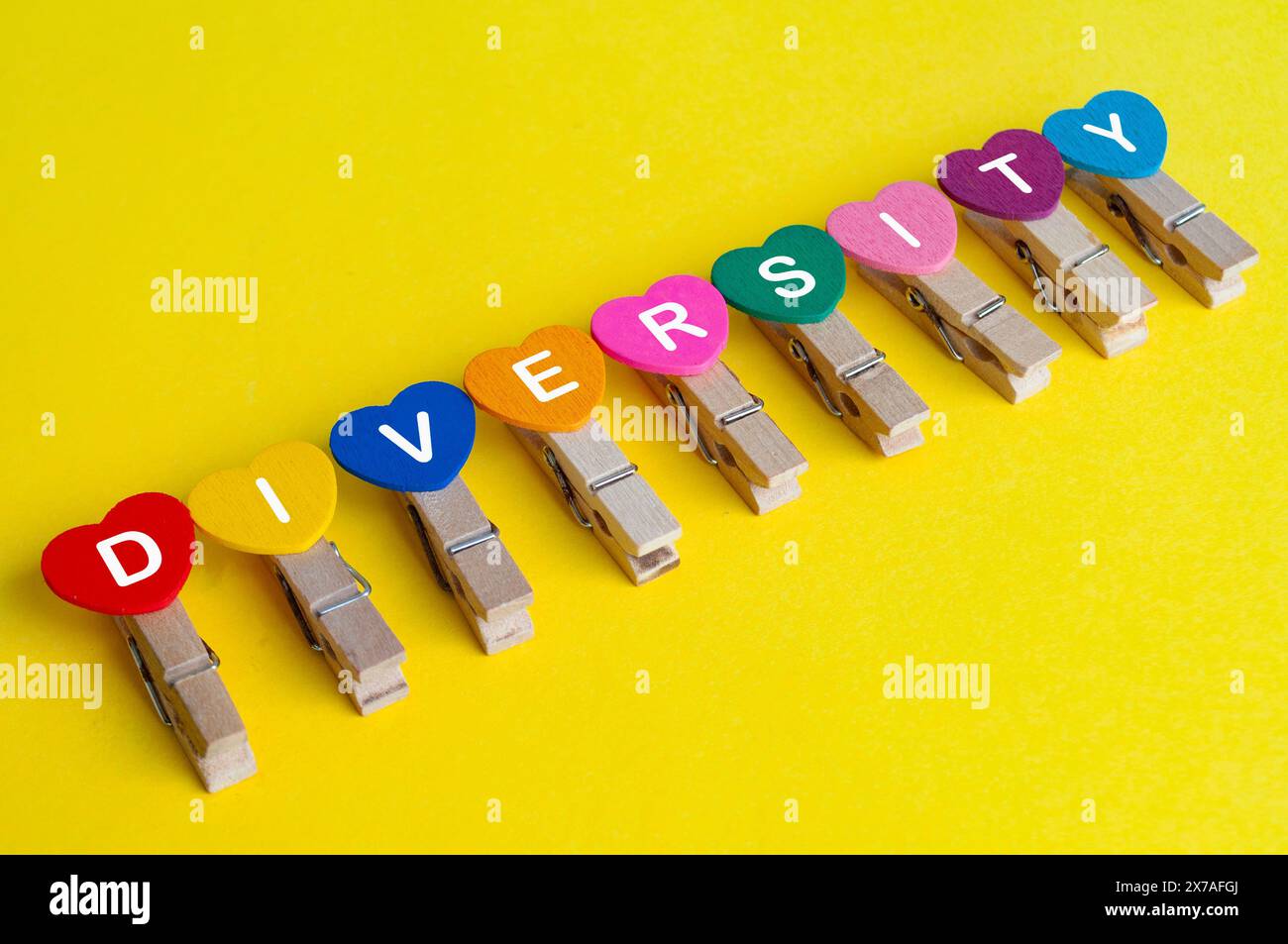 Diversity text on hearth shape on yellow background Stock Photo - Alamy