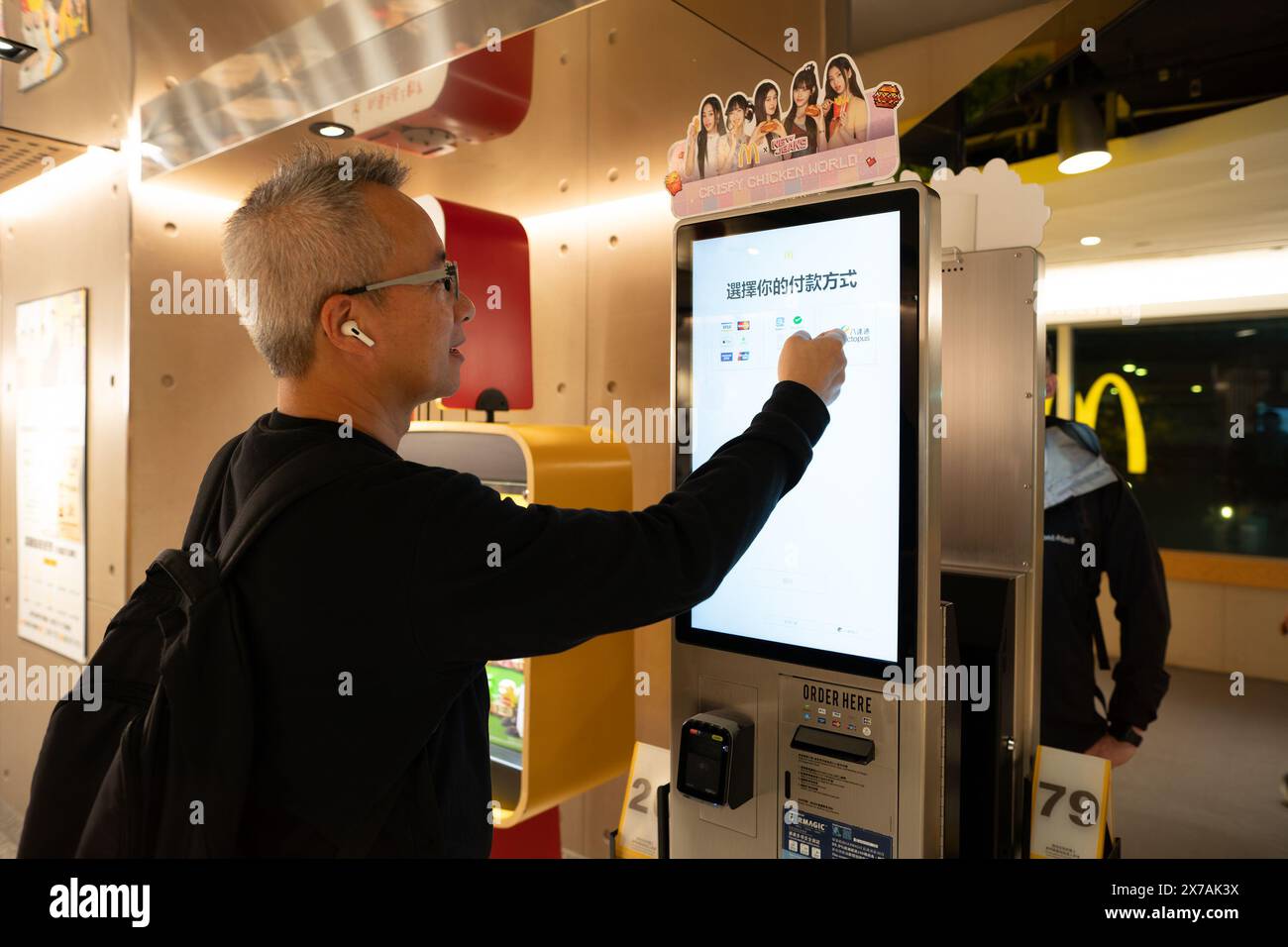 HONG KONG, CHINA - DECEMBER 04, 2023: man use self-service ordering kiosk at McDonald's fast ...