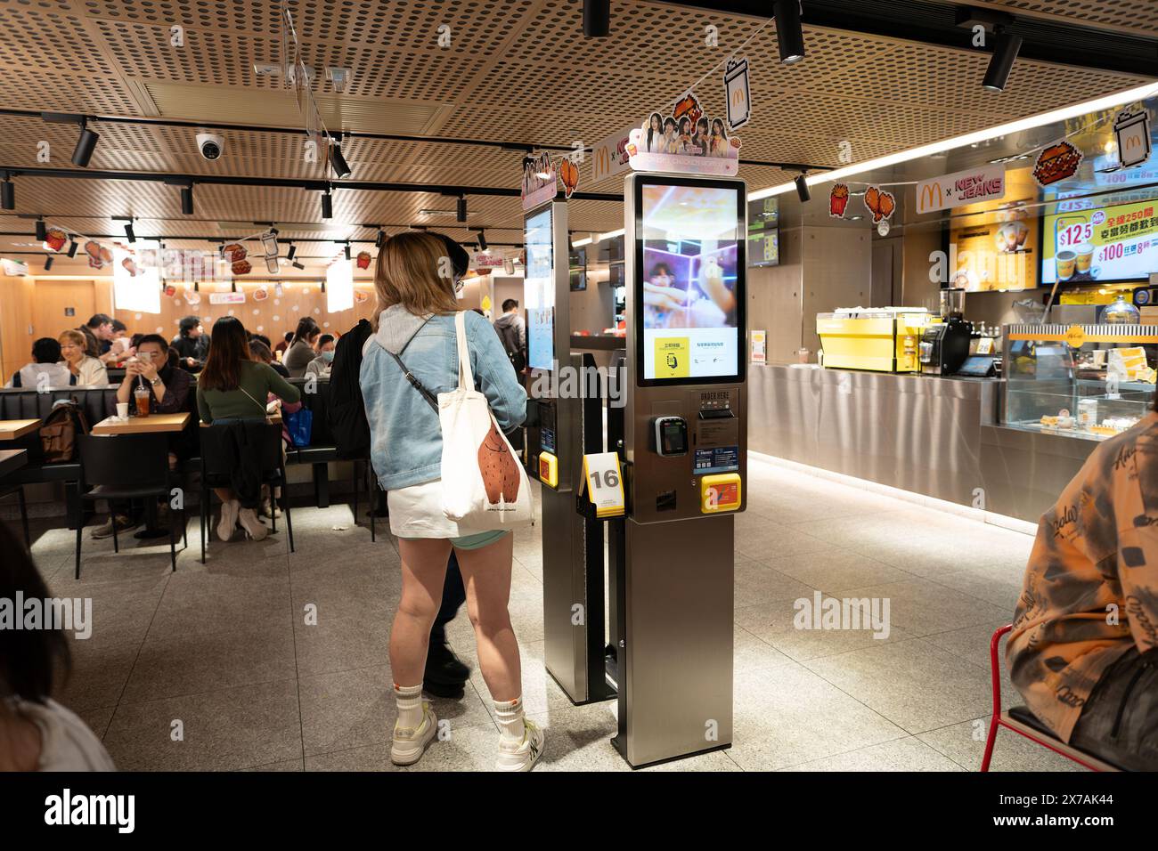HONG KONG, CHINA - DECEMBER 04, 2023: couple self-service ordering kiosk at McDonald's fast-food ...