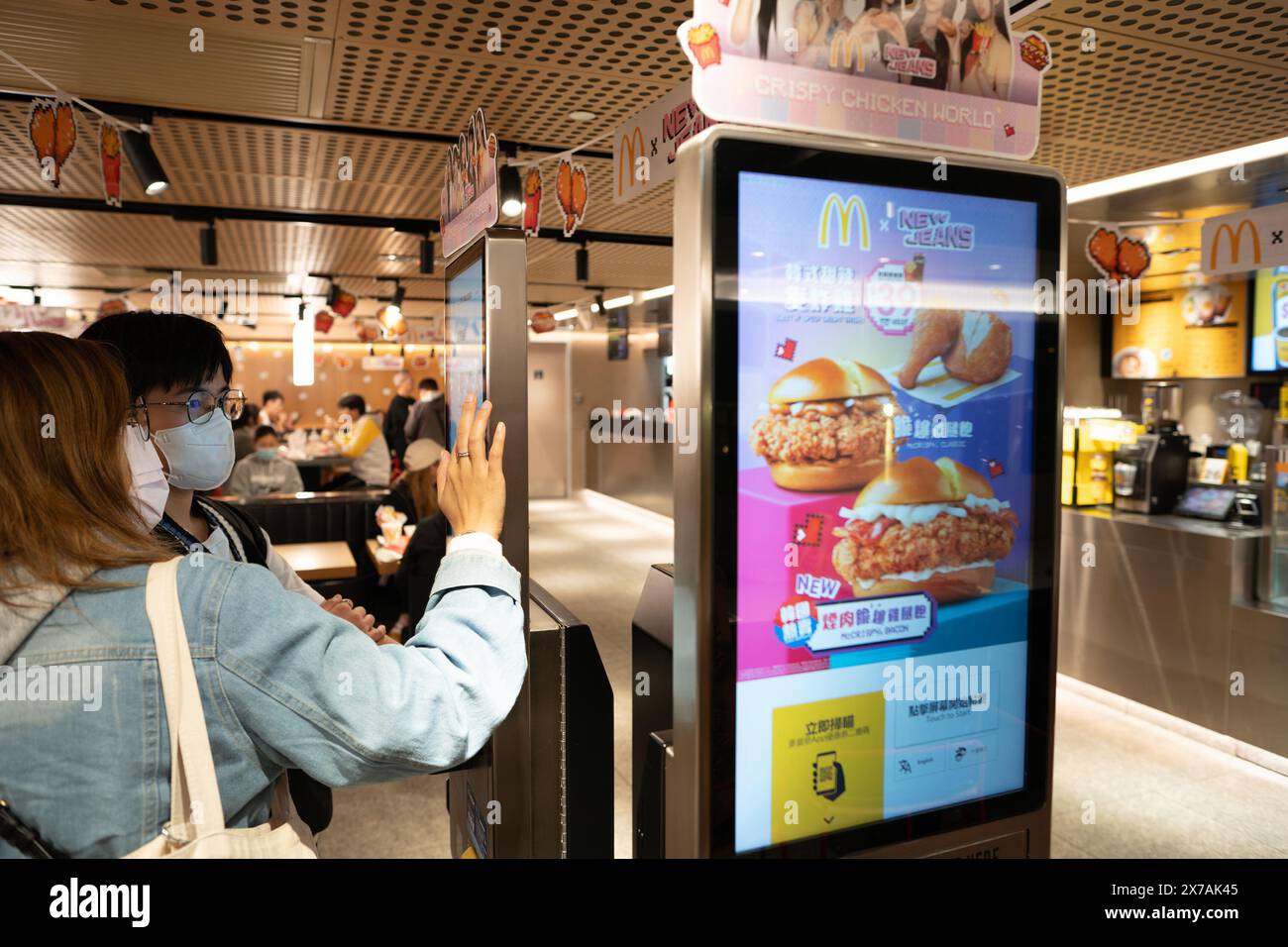 HONG KONG, CHINA - DECEMBER 04, 2023: couple self-service ordering kiosk at McDonald's fast-food ...