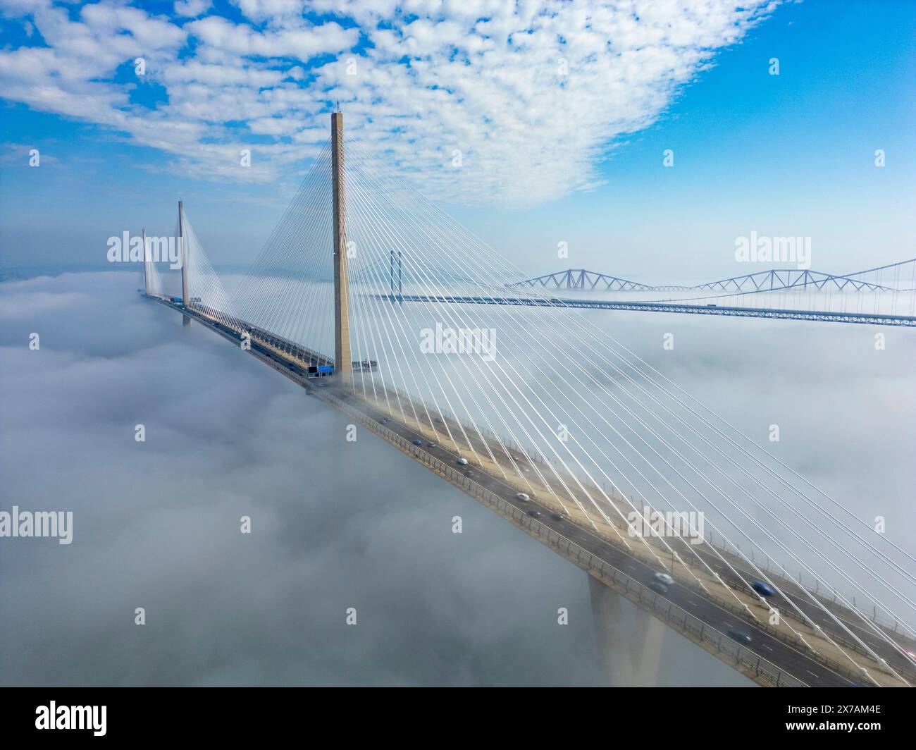 Aerial view of Queensferry Crossing Bridge emerging from sea fog or ...