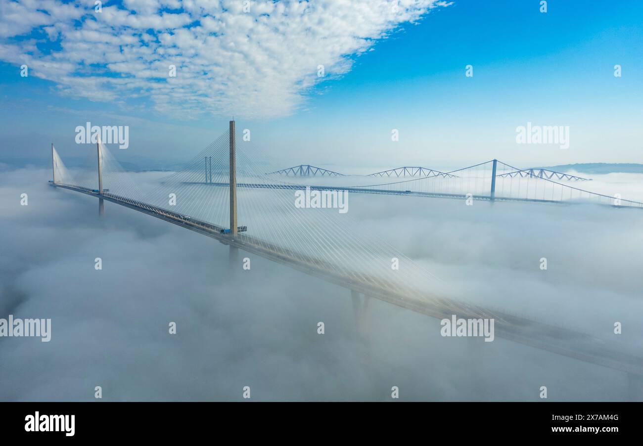 Aerial view of Queensferry Crossing Bridge emerging from sea fog or ...
