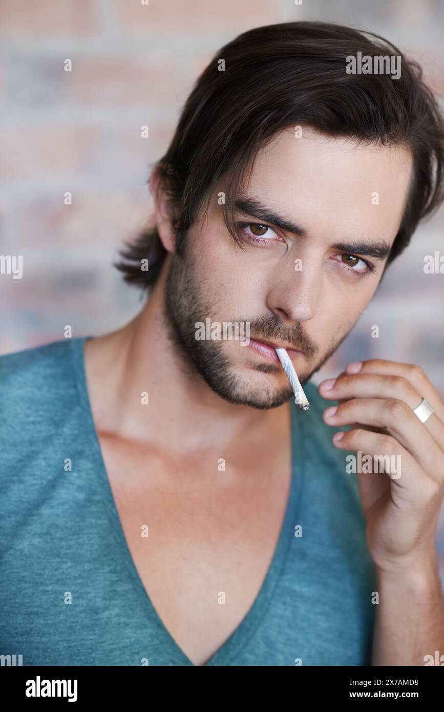 Brick wall, portrait and man smoking cigarette, tobacco and 420 to ...