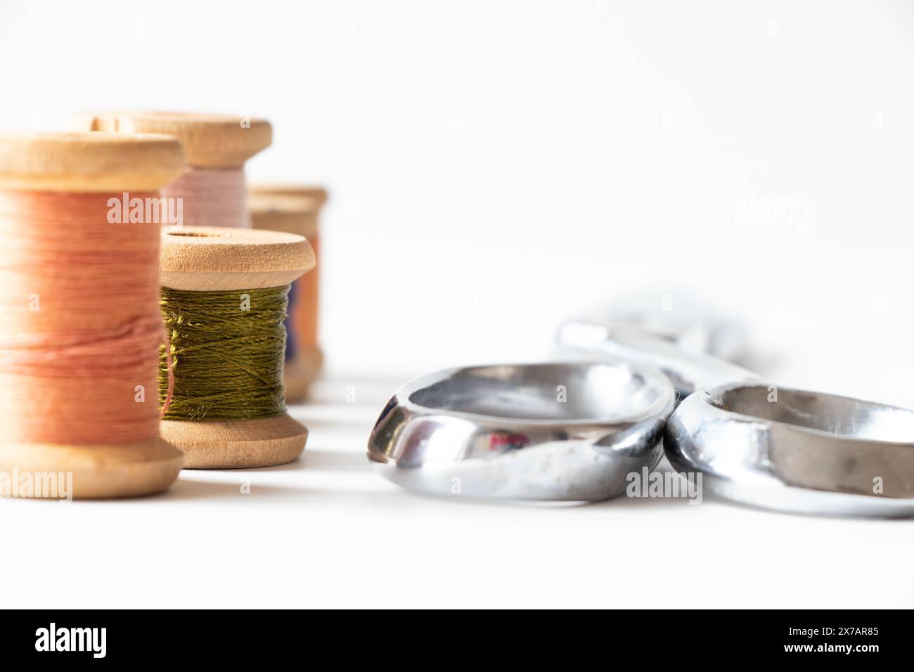 Threads on wooden old cats and sewing scissors on a white background ...