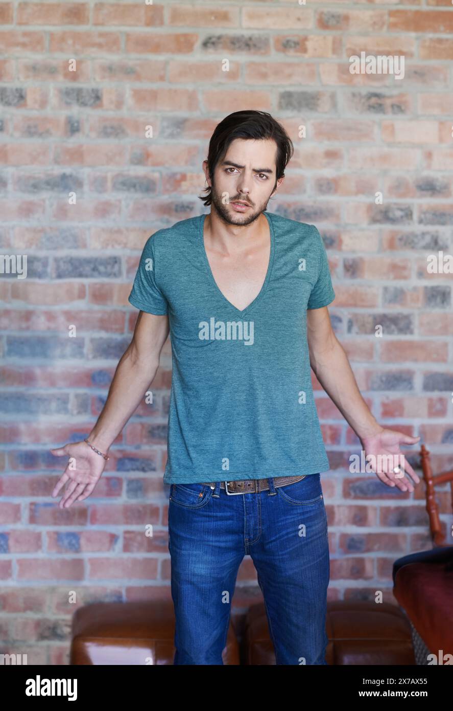 Man, portrait and question gesture by brick wall confused with doubt ...