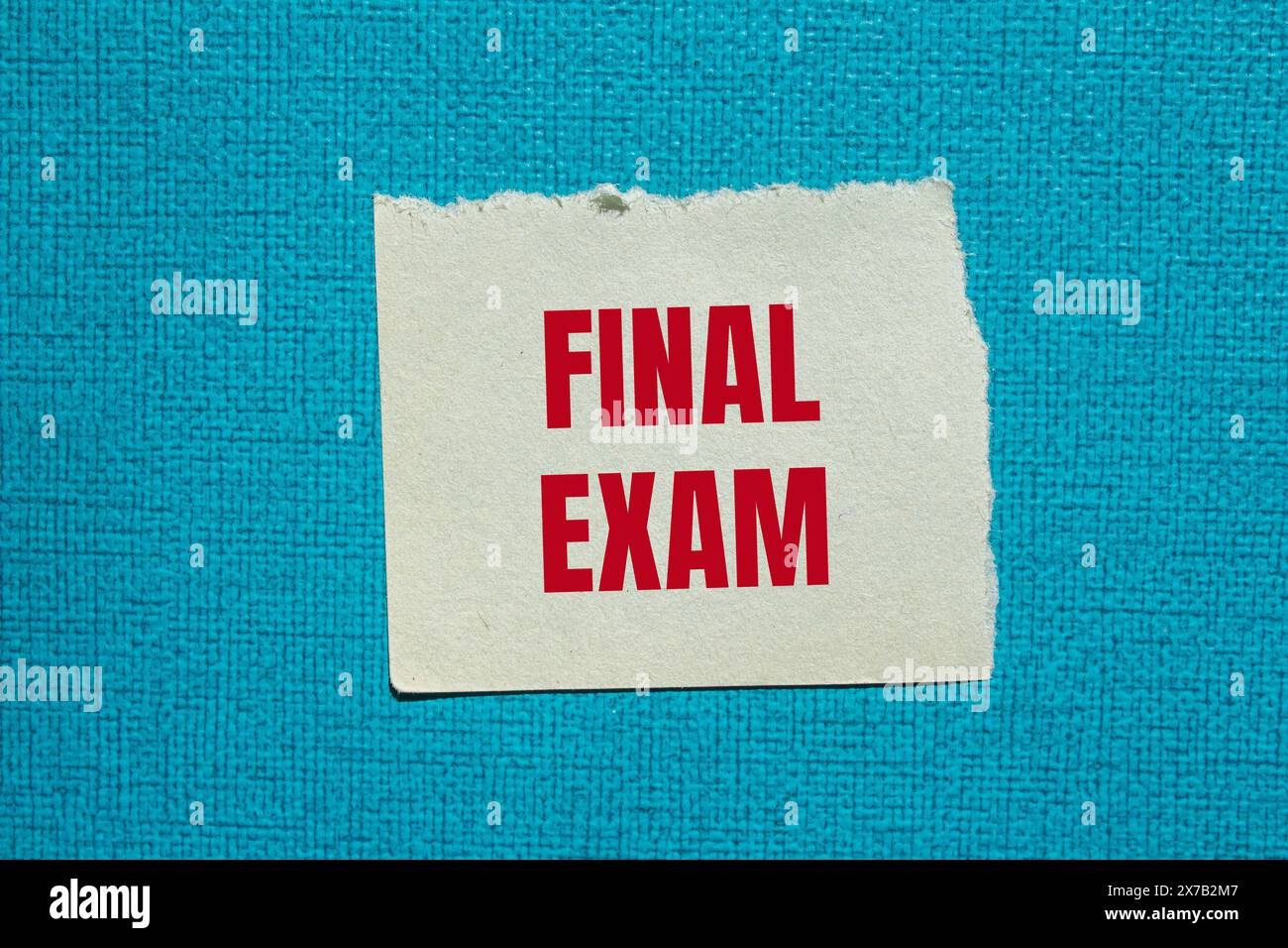 Final exam words written on ripped paper with blue background ...
