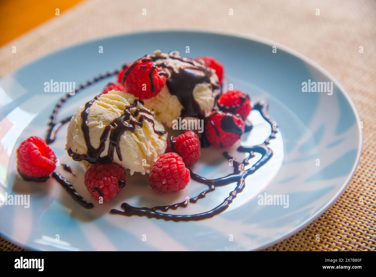 Ice cream with raspberries and chocolate syrup Stock Photo - Alamy
