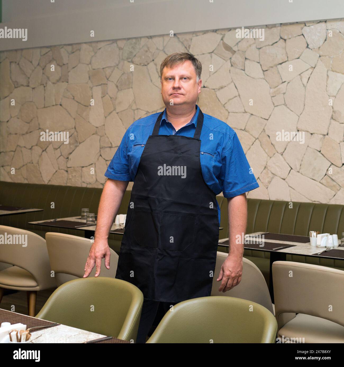 A polite waiter offers seat for cafe guests Stock Photo - Alamy