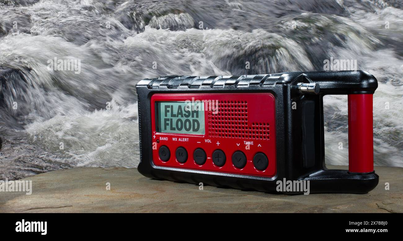 Red battery powered weather radio showing the flash flood warning ...