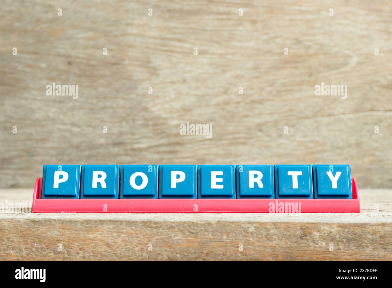 Tile letter on red rack in word property on wood background Stock Photo ...