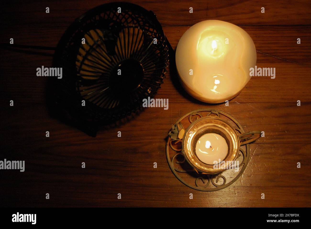 Three lighted flames and a desk fan, table top still life Stock Photo ...