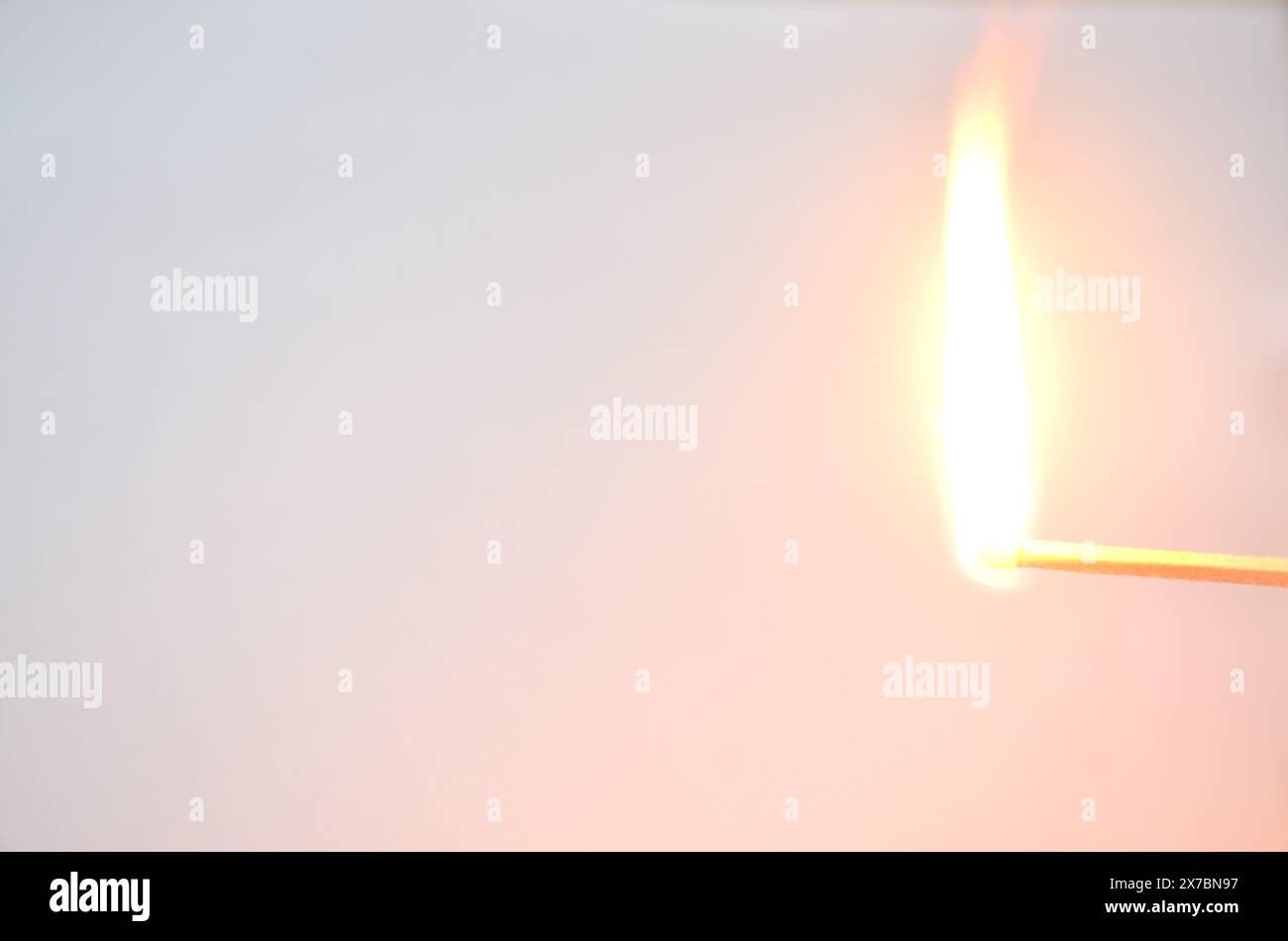 red head matchstick lighting on in white background Stock Photo - Alamy