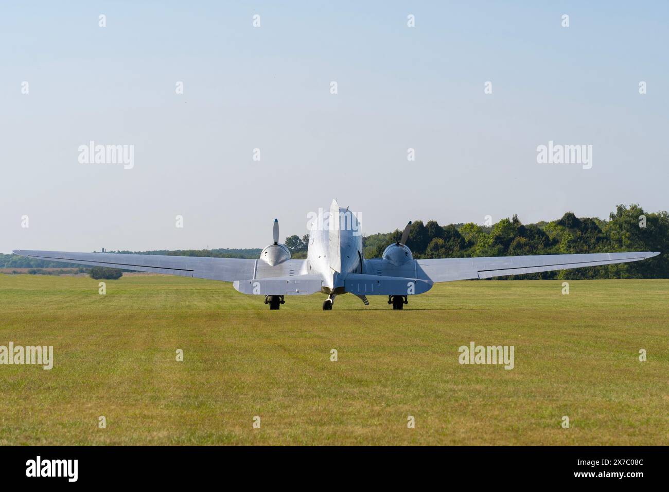 Metallic old twin engine propeller Li-2 transport plane in a field from ...