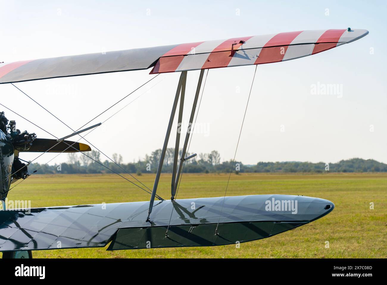 Wings of an old Po-2 biplane with a grass runway in the background ...