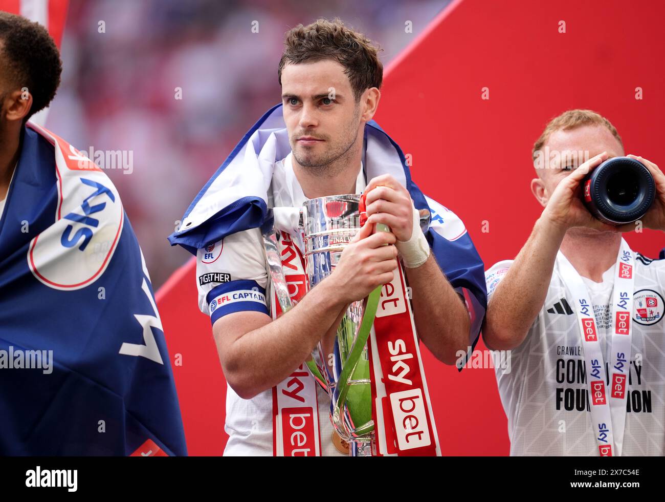 Crawley Town's Dion Conroy celebrates on the pitch with the trophy ...