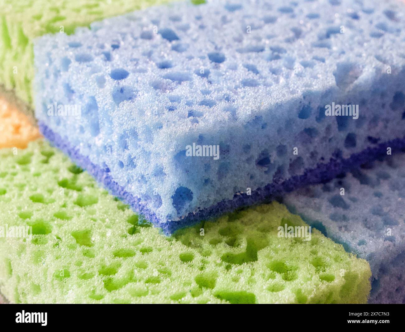 Cleaning Supplies. A collection of sponges in blue, green, and yellow ...