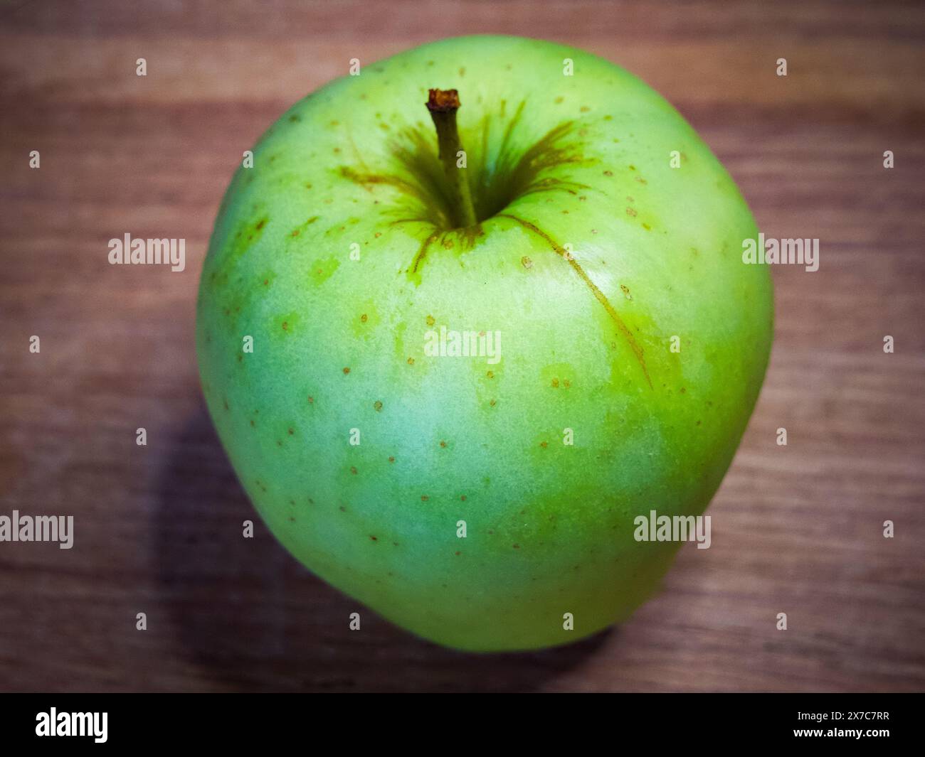 The apples smooth, shiny skin has tiny spots, showcasing natural growth ...