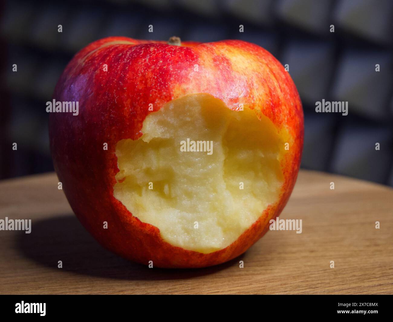 Apple with Bite. Partially eaten apple on wood, highlights natural food ...