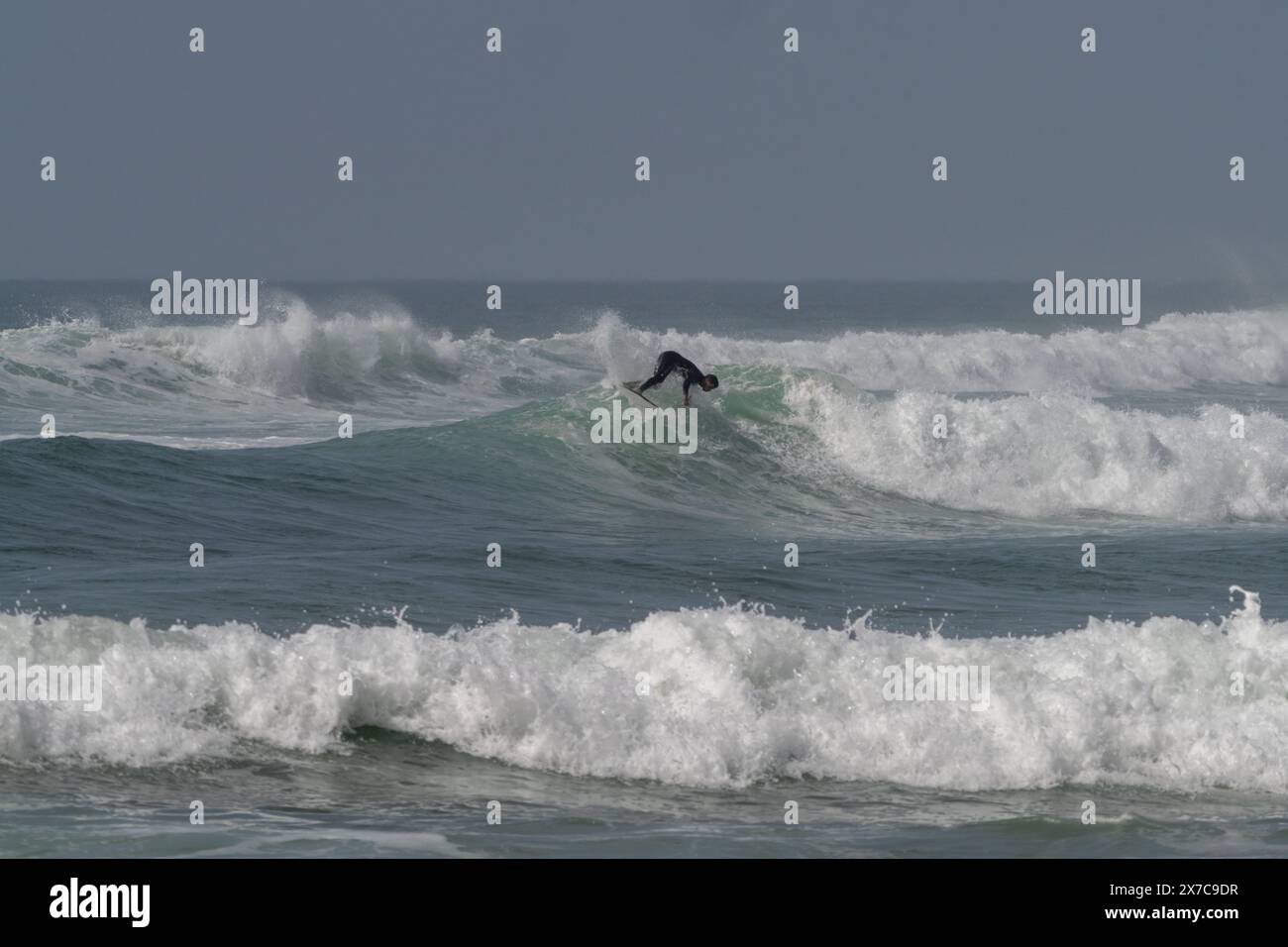Sidi Ifni, Morocco - 17 March, 2024: man surfing a large wave off the ...