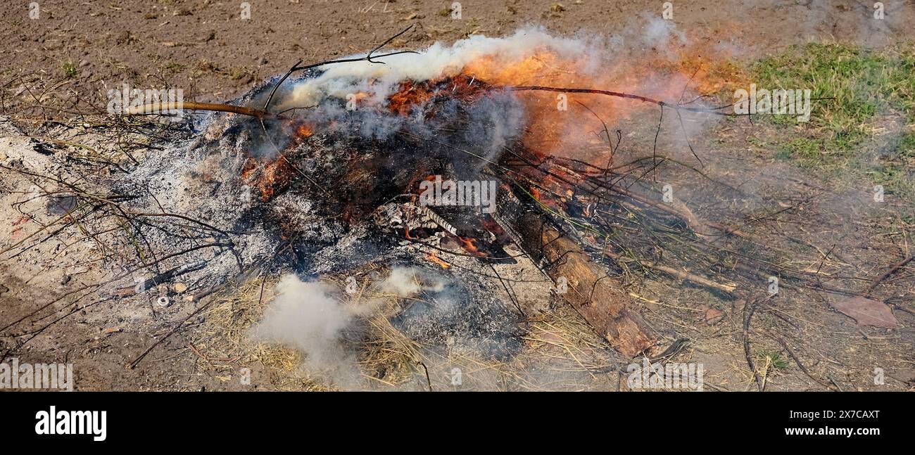 The aftermath of a bonfire with lingering flames Stock Photo - Alamy