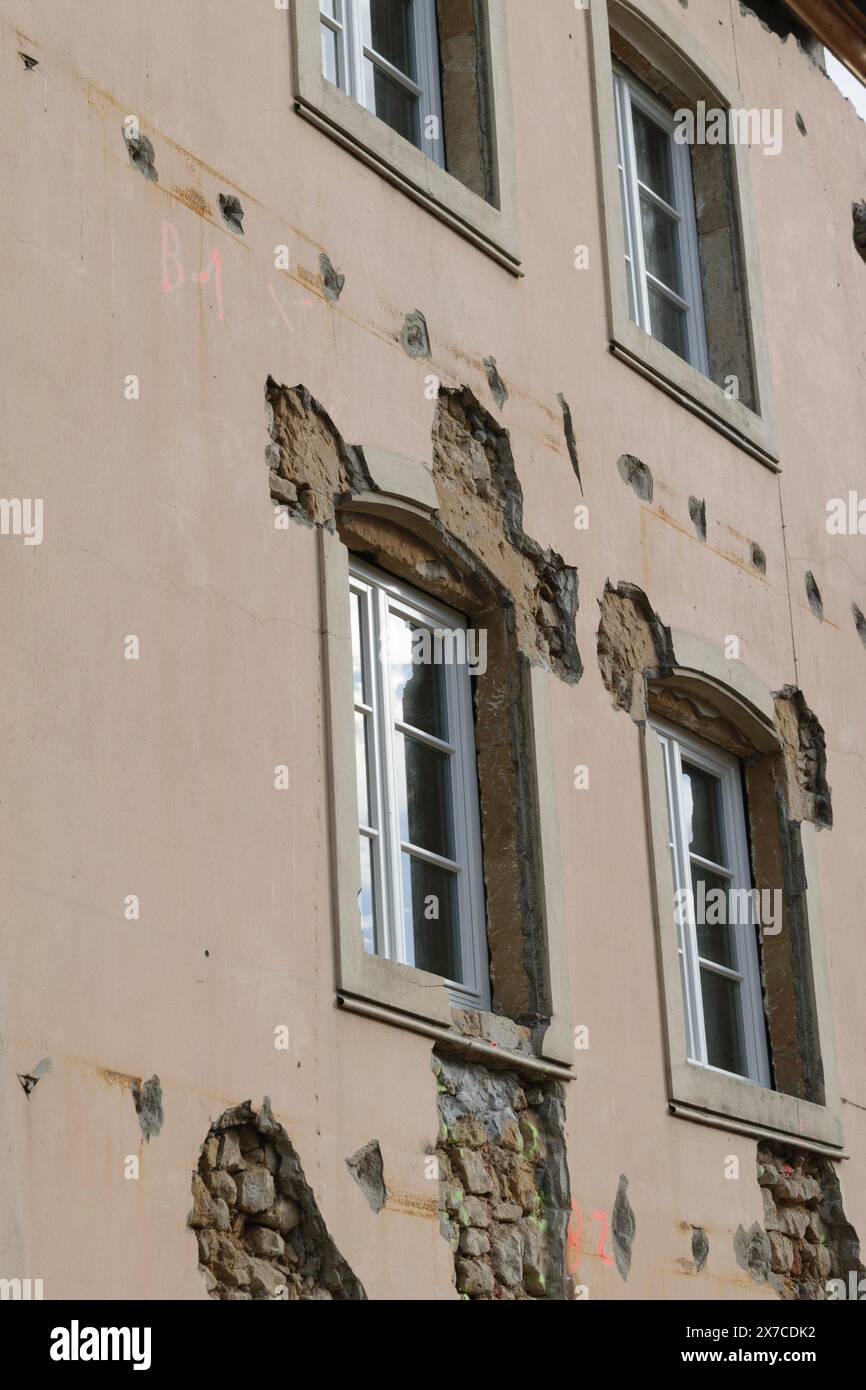 A close-up view of an old, deteriorating building facade with visible ...