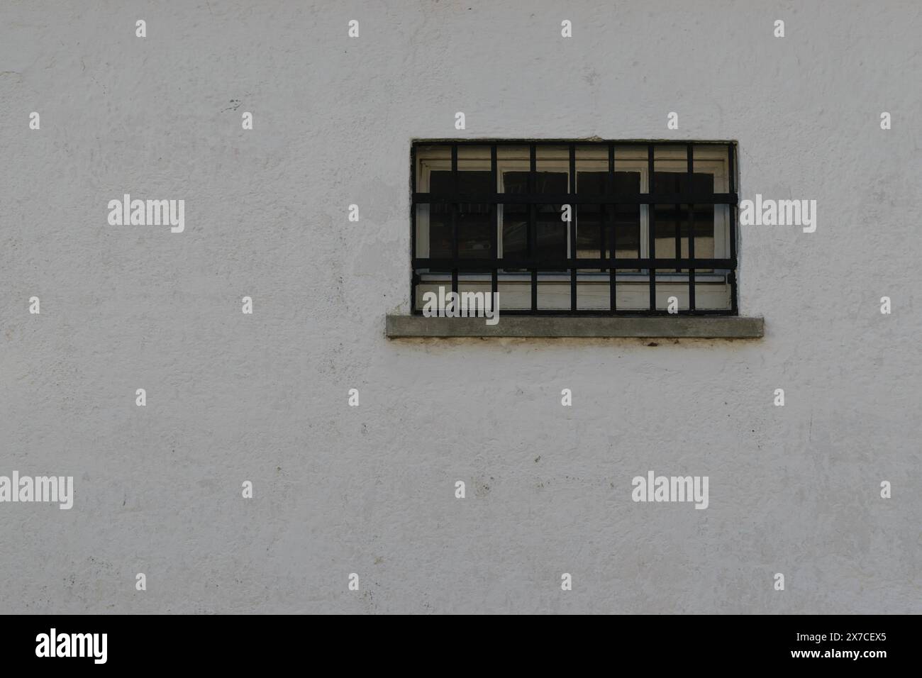 A small barred window on a plain white wall Stock Photo - Alamy