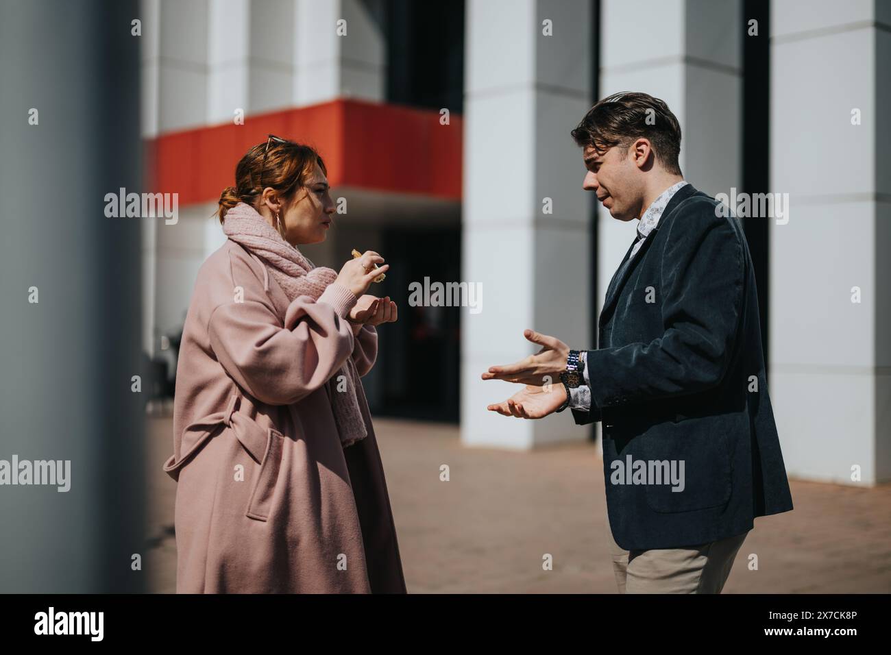 Corporate discussion between two associates outdoors with modern ...