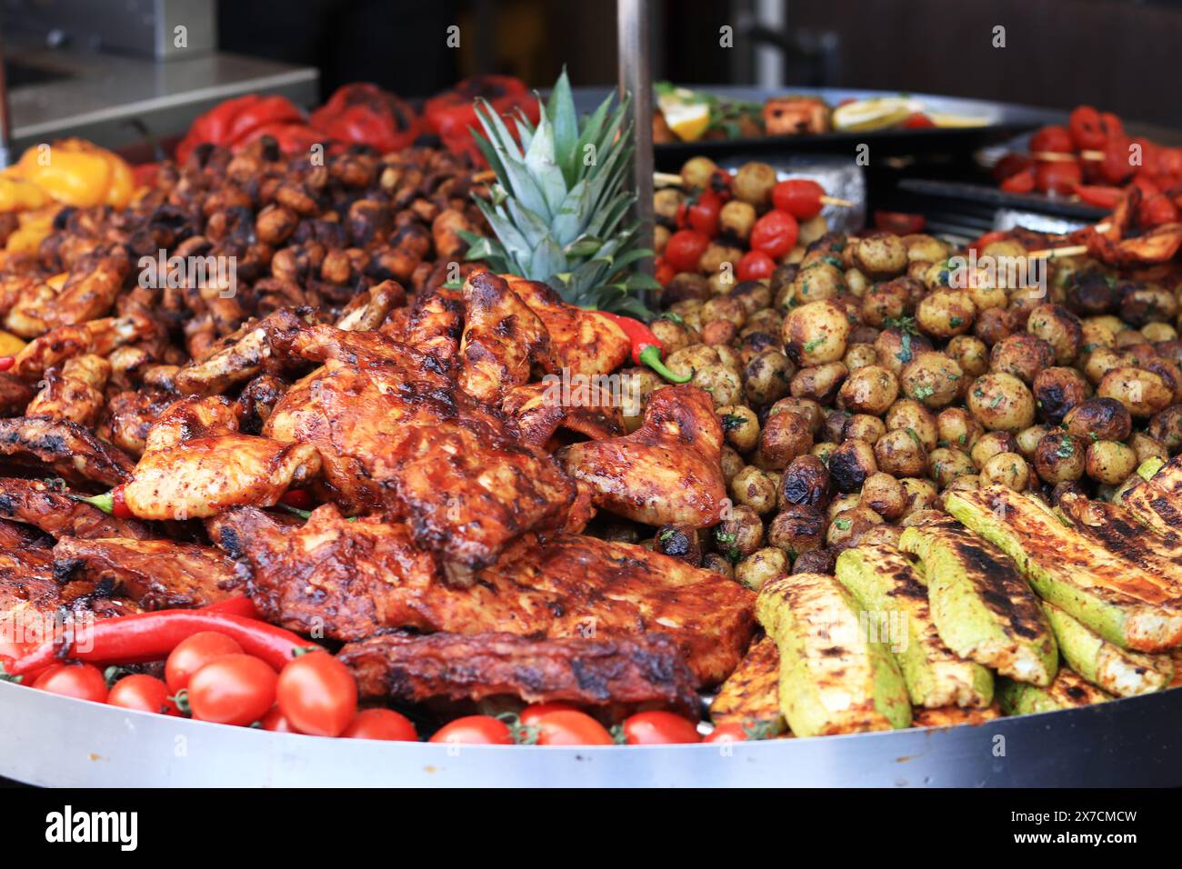 Large round rotating grill with assorted meats and vegetables. Rotary ...