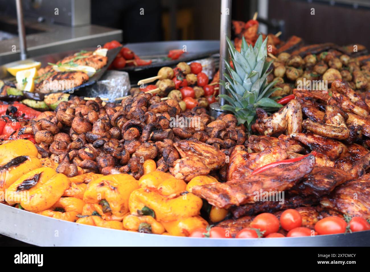 Large round rotating grill with assorted meats and vegetables. Rotary ...