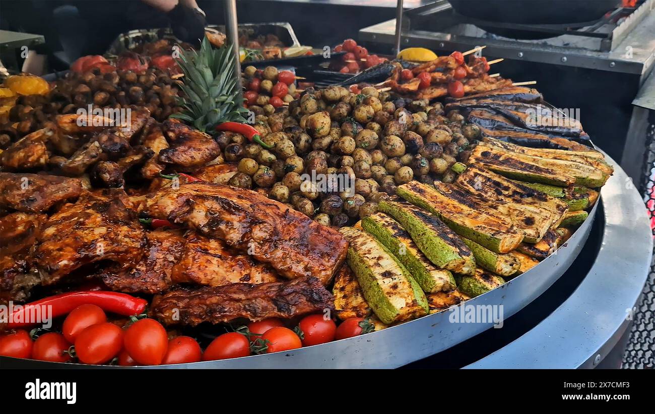Large round rotating grill with assorted meats and vegetables. Rotary ...