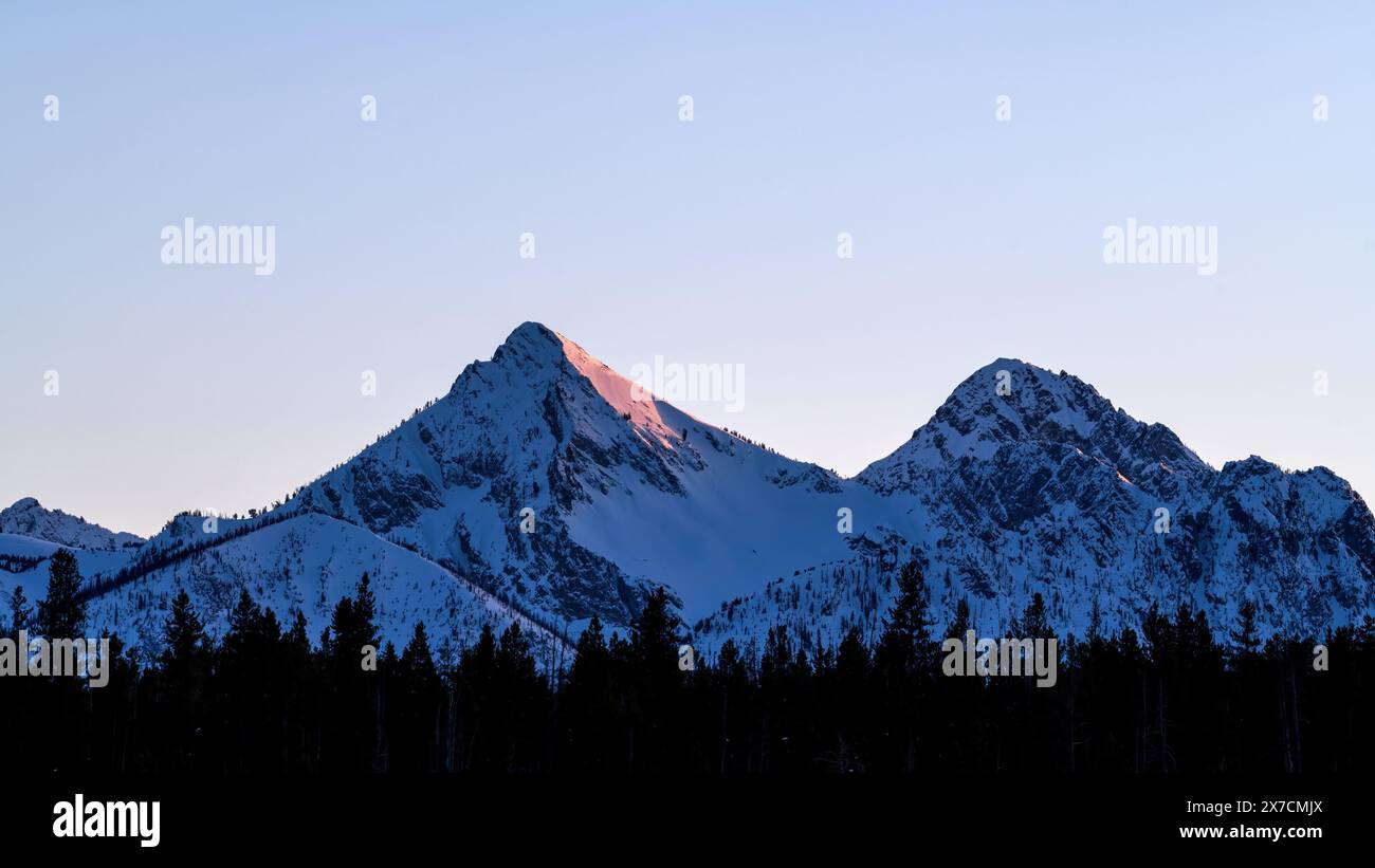 Warm colors of sunset reflection from high peaks Stock Photo - Alamy