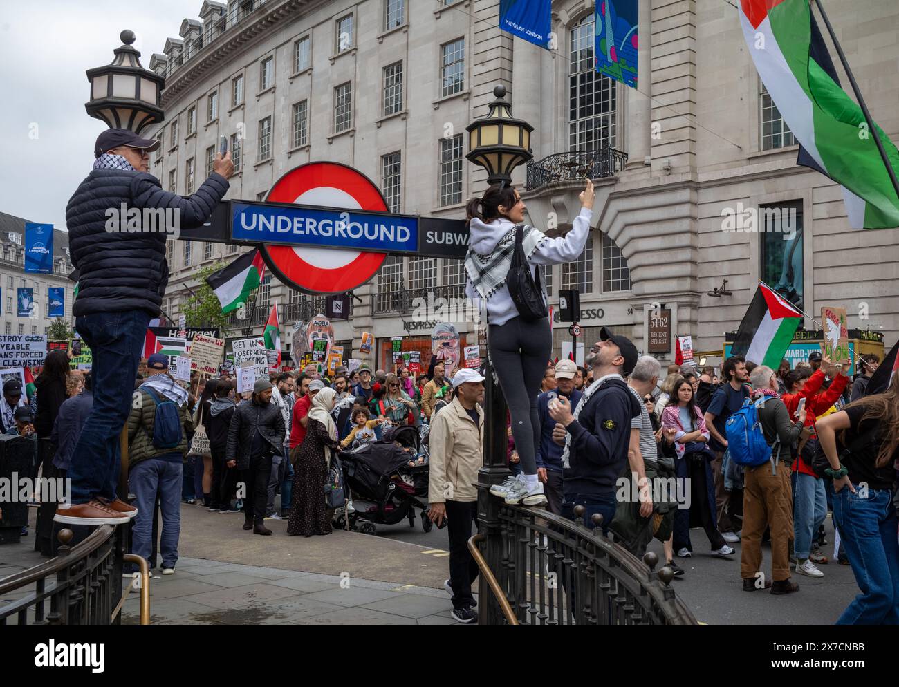 London, UK. 18 May 2024: People stand on railings at Piccadilly Circus ...