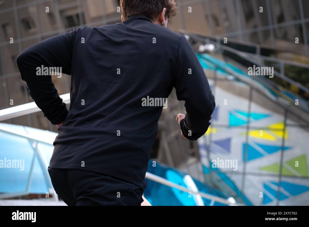 Young athlete running down stairs, doing dynamic exercise outdoors ...