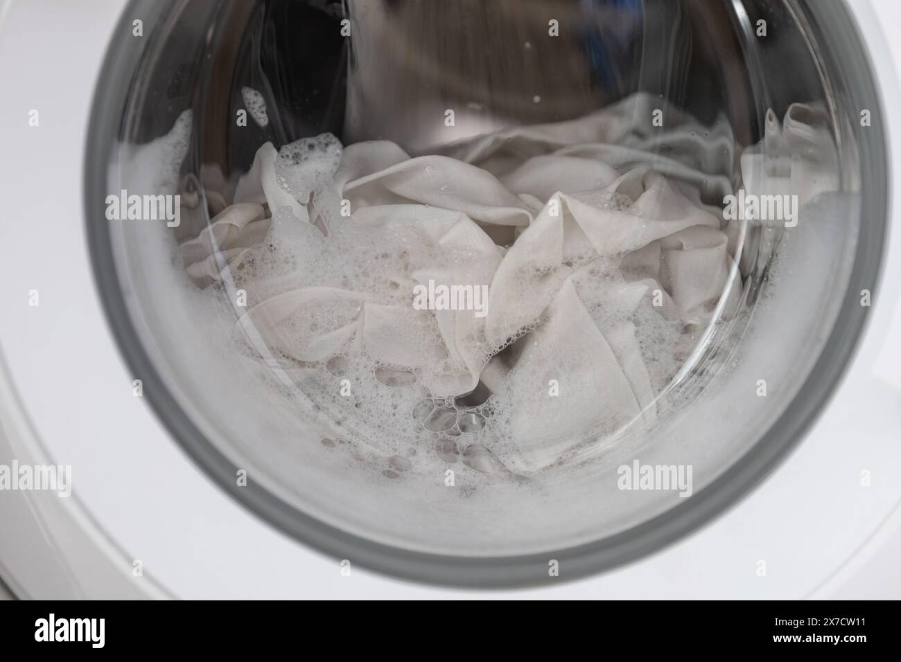 Close-up laundry running washing machine at home, amid a washing cycle ...