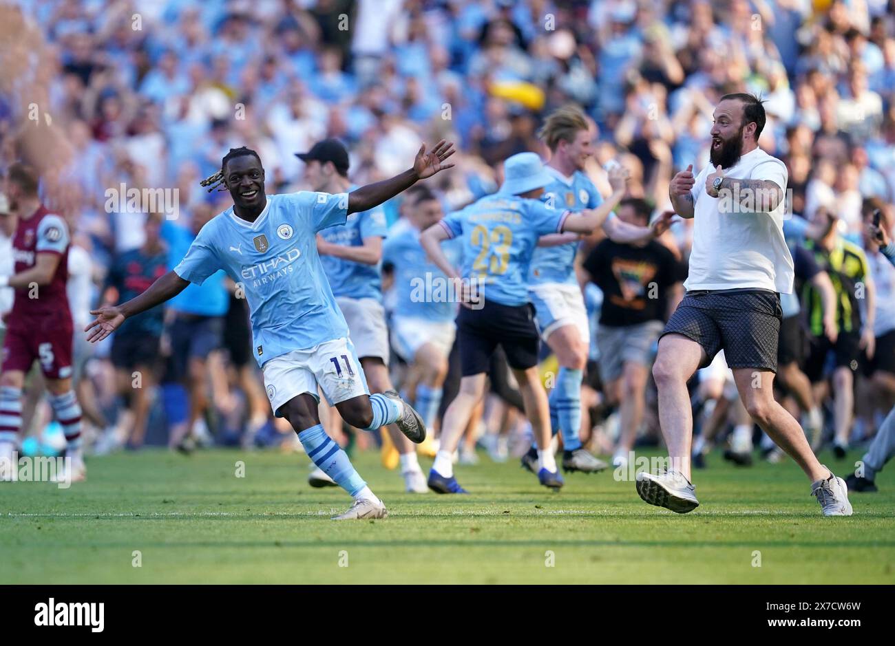 Manchester City's Jeremy Doku celebrates as fans invade the pitch ...