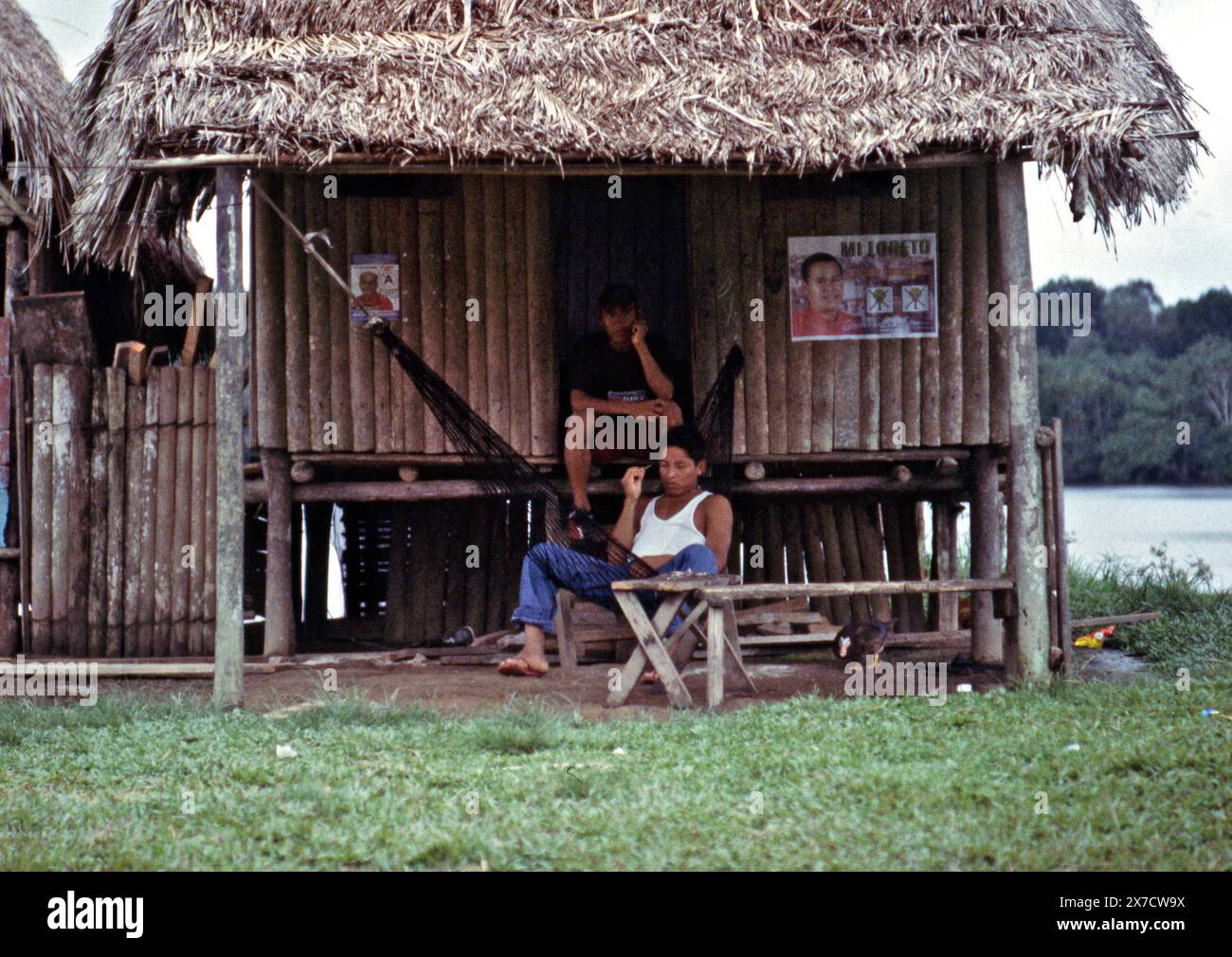 Indigenous Cocama men relaxing outside their village house in the ...