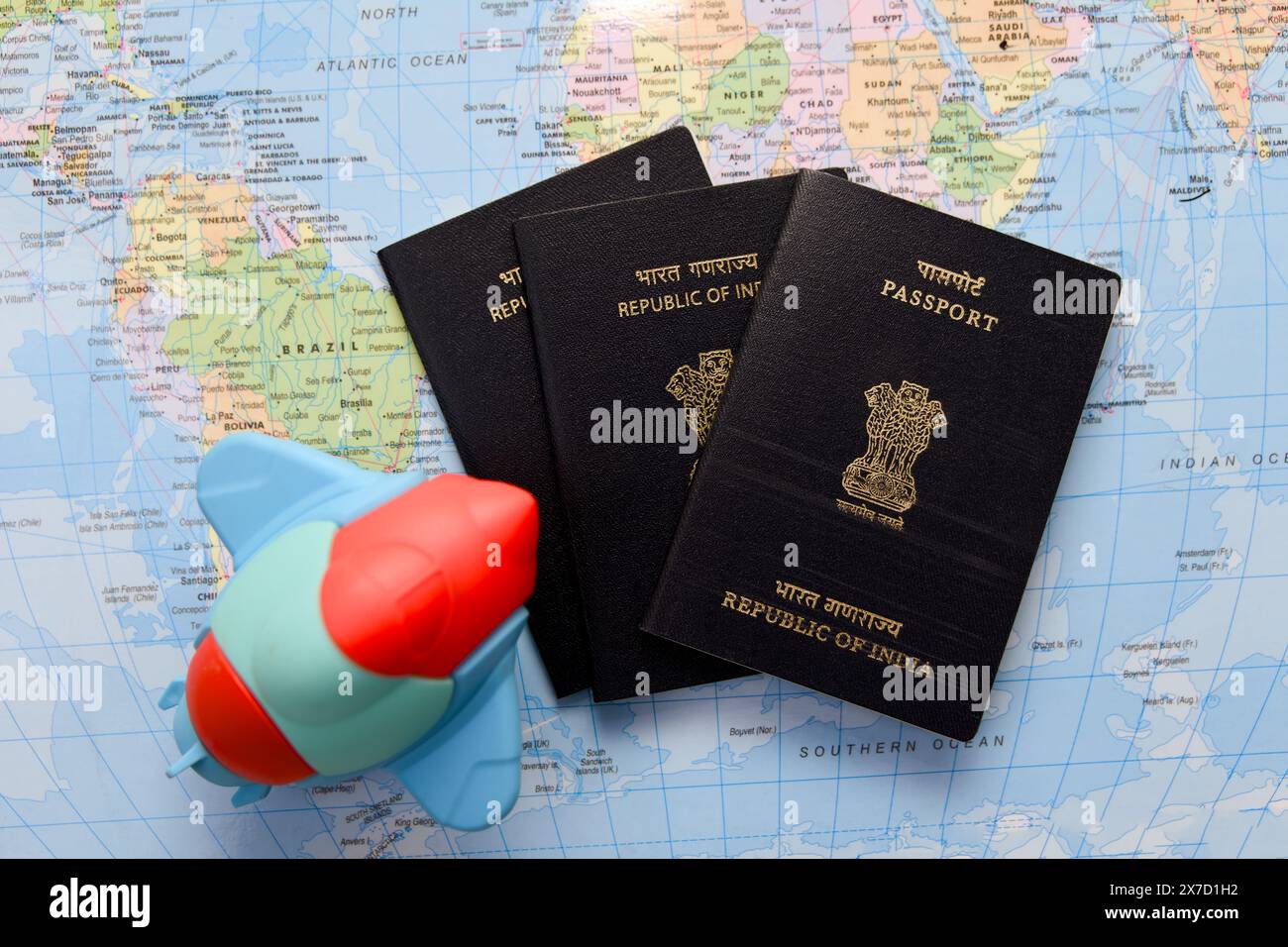 Two Indian passports lie open on a world map, with a toy rocket ...