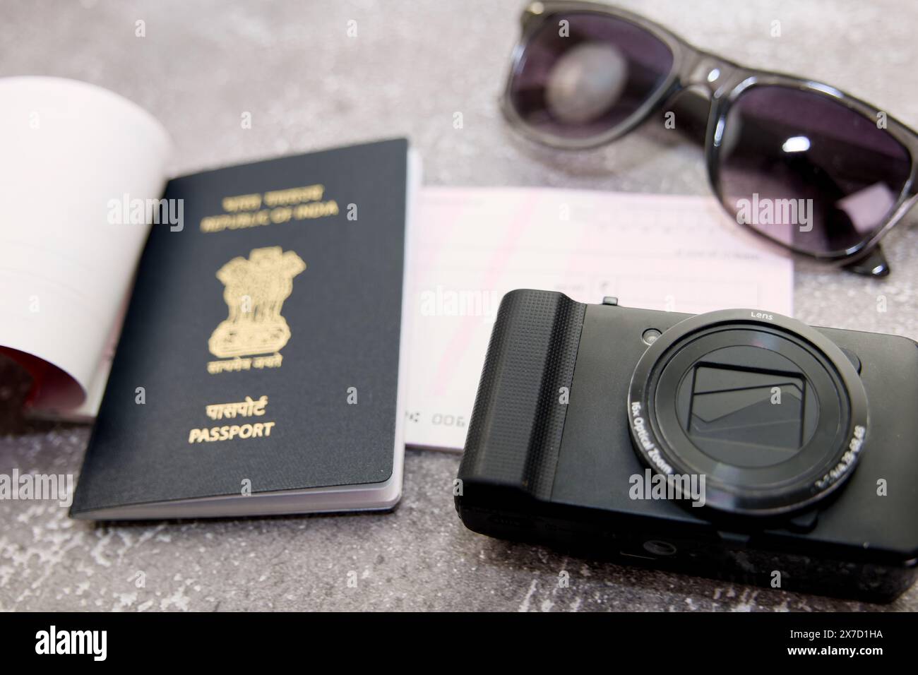 This image is about Indian passport camera and sunglasses on a gray ...