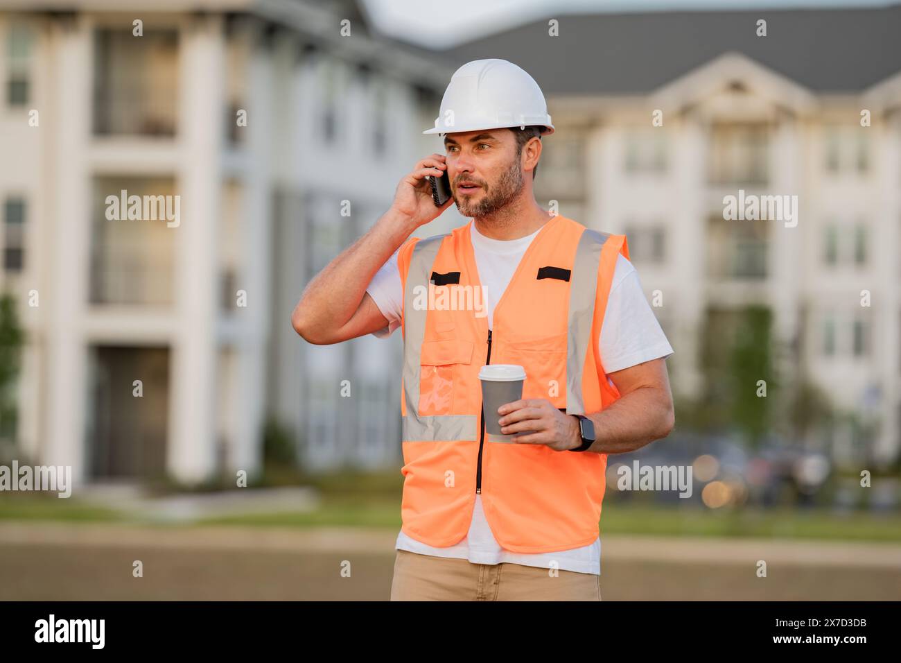Engineer builder drinking take away coffee using phone on break ...