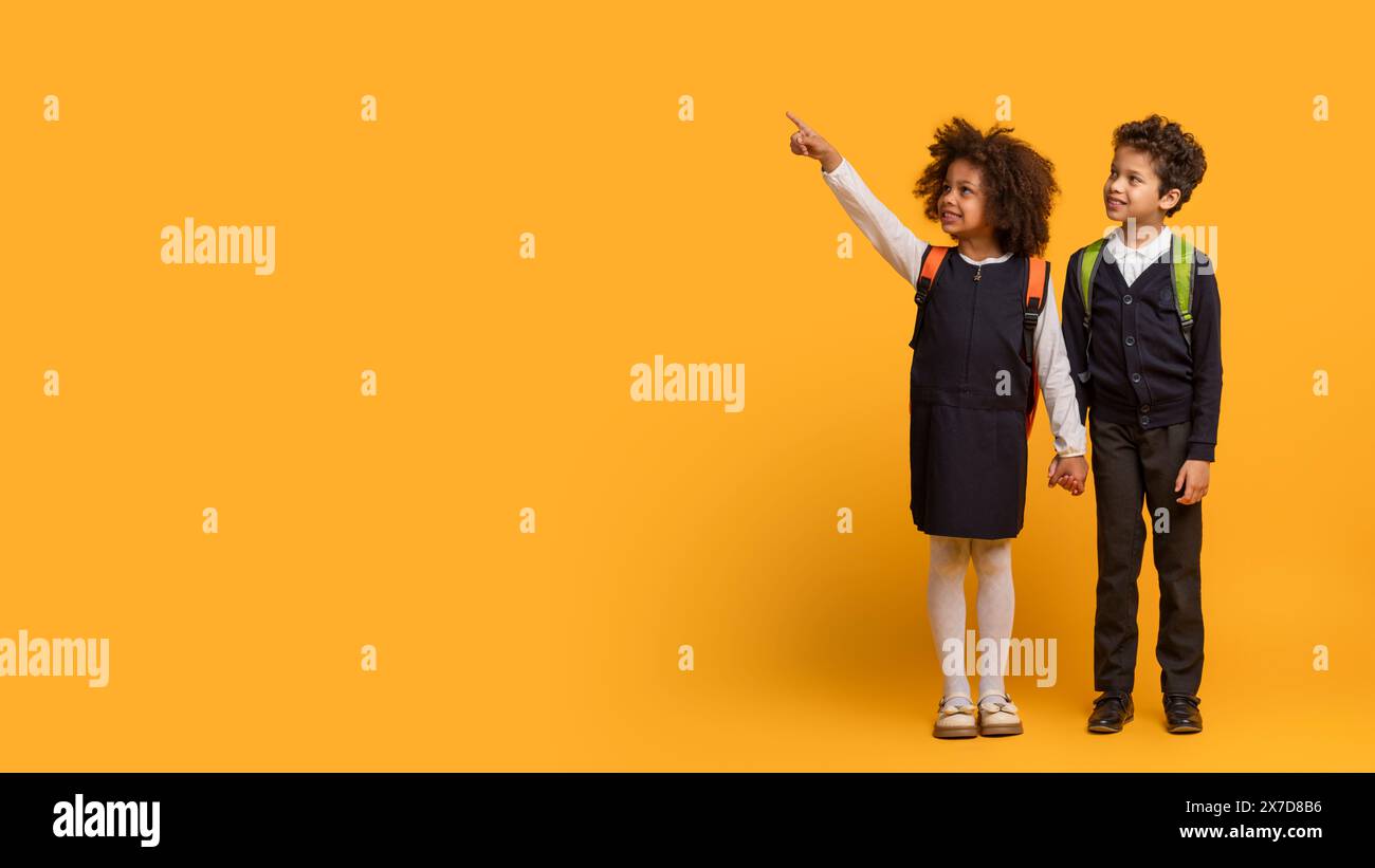 Two Young Students in Uniform Standing Against Yellow, Copy Space Stock ...