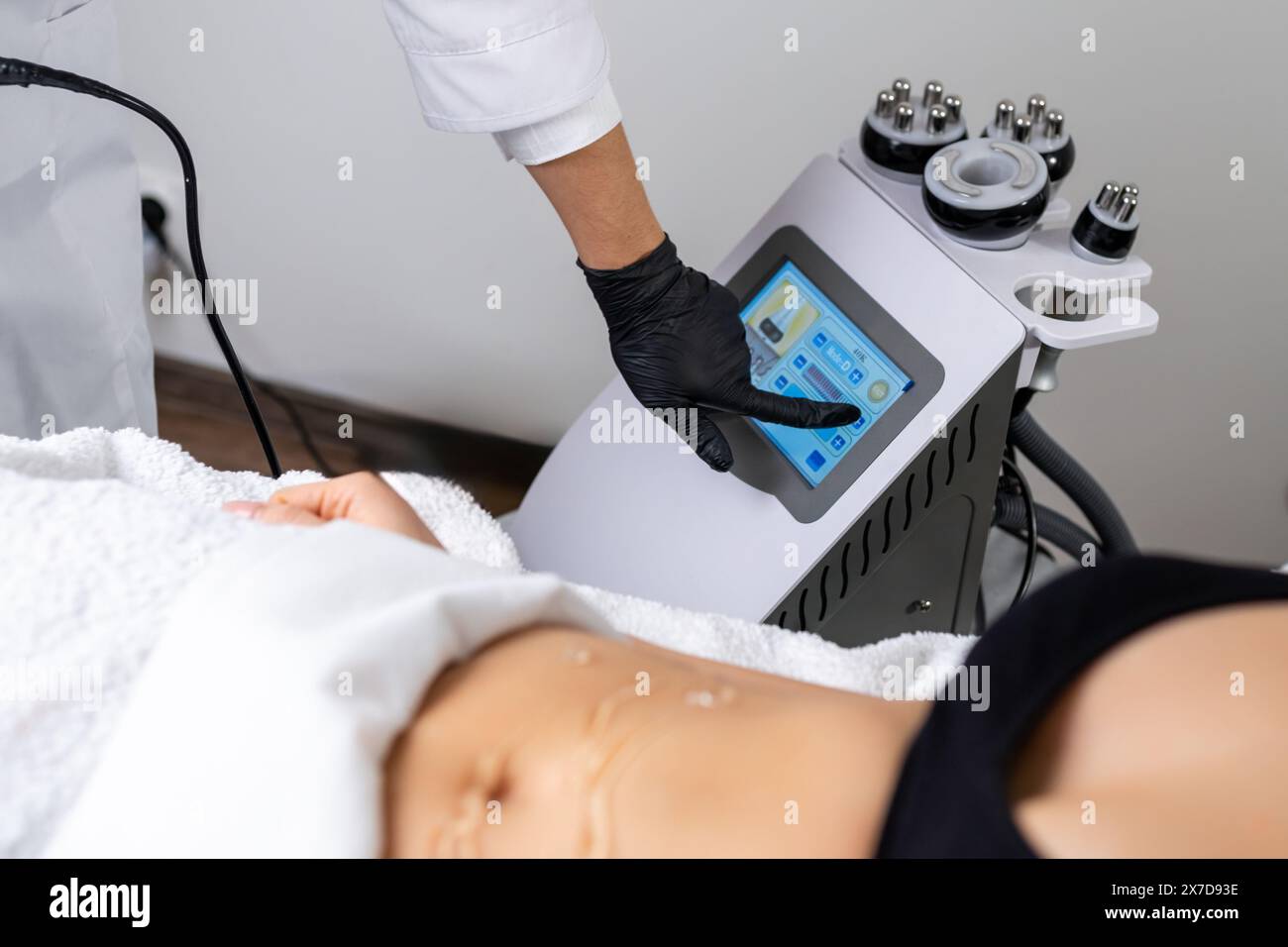 Woman calibrates vacuum cavitation device for effective results. Worker ...