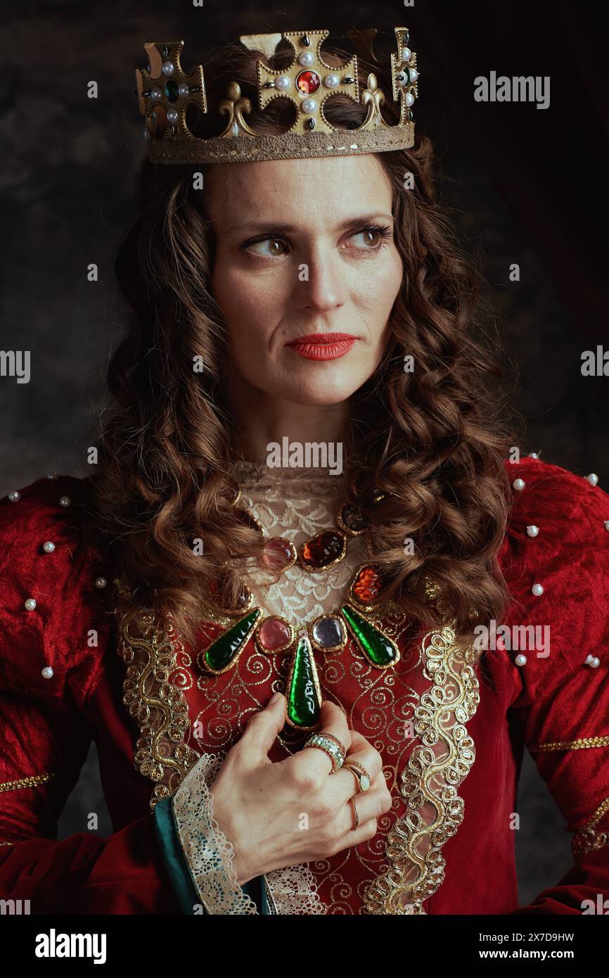 medieval queen in red dress with crown on dark gray background Stock ...