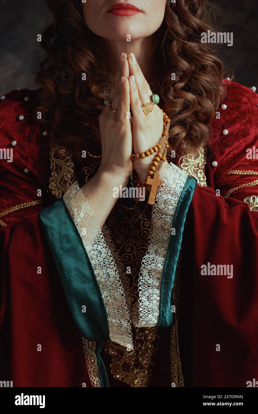 Closeup on medieval queen in red dress with rosary praying Stock Photo ...