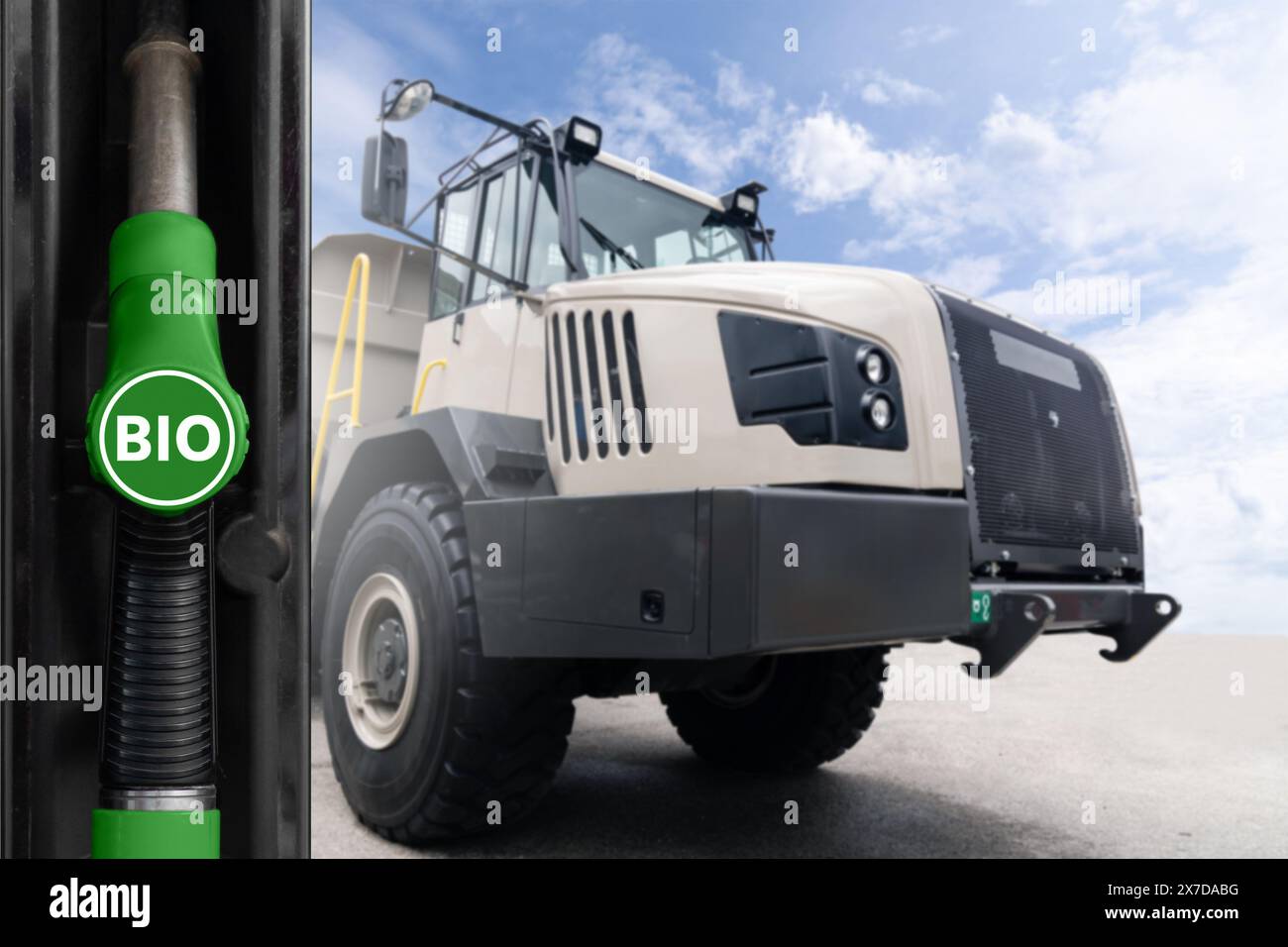 Hand with biofuel filling nozzle on a background of mining truck ...