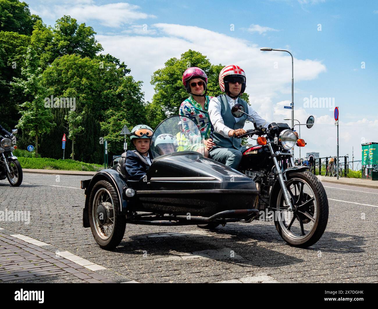 A family rides a motorbike with a sidecar. The Distinguished Gentleman ...