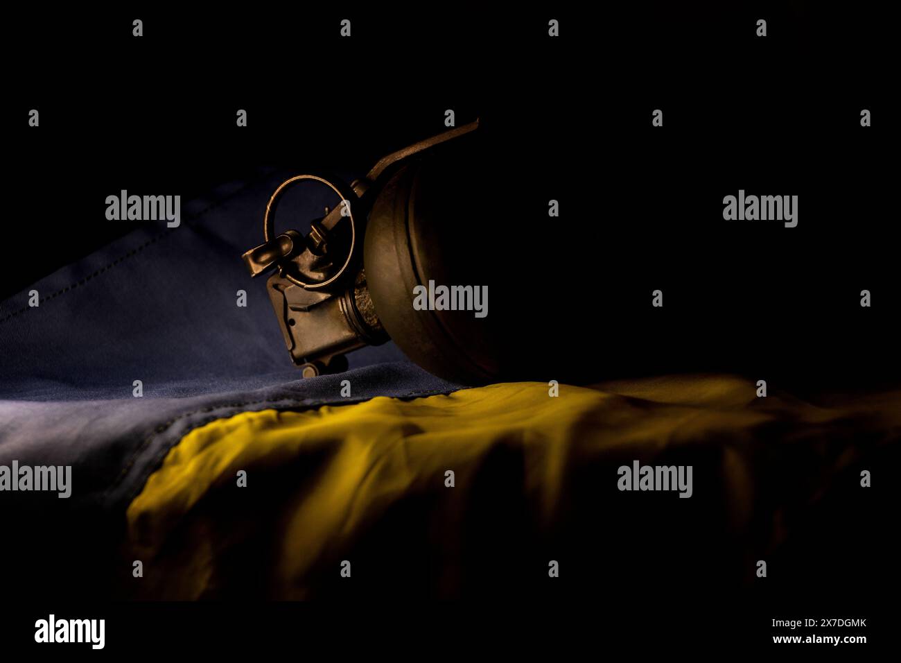 A hand grenade lies on the flags of Ukraine in the dark, the war in ...