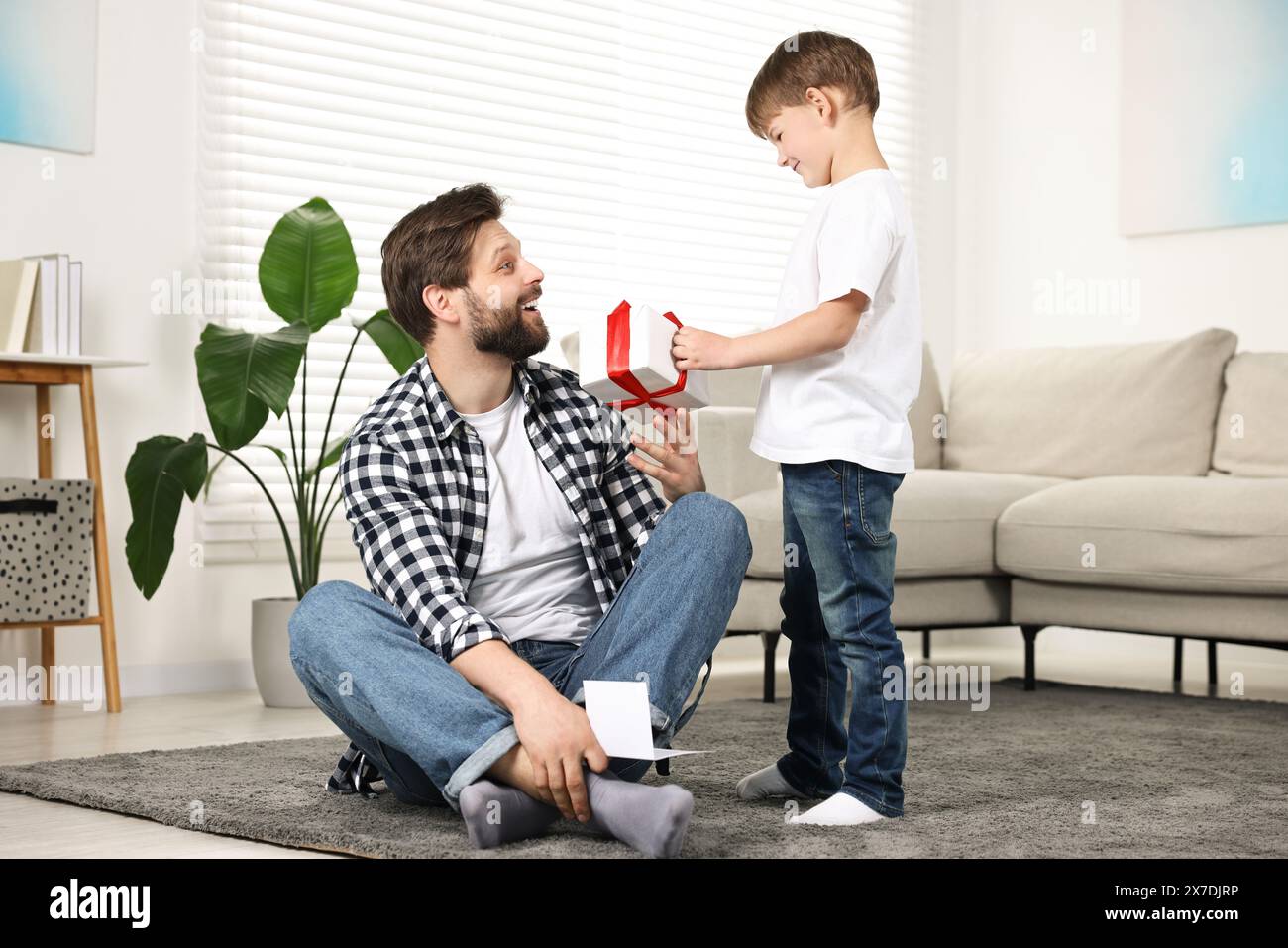 Happy Father's Day. Son giving gift box to his father with greeting ...